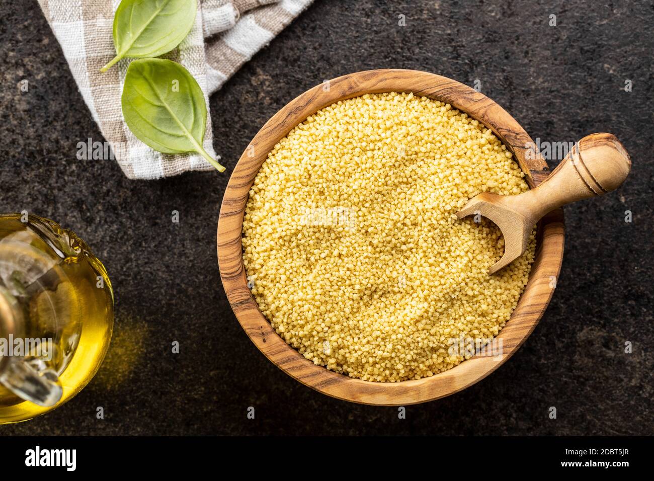 Dry yellow couscous in wooden bowl and wooden scoop. Top view Stock ...