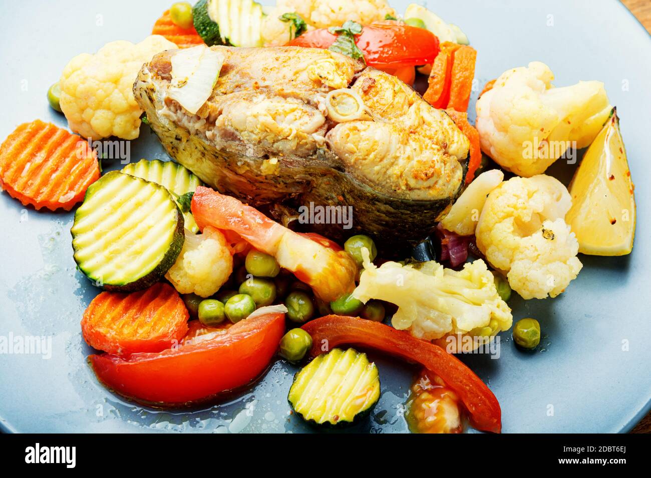 Baked fish steaks with grilled vegetables on plate Stock Photo - Alamy