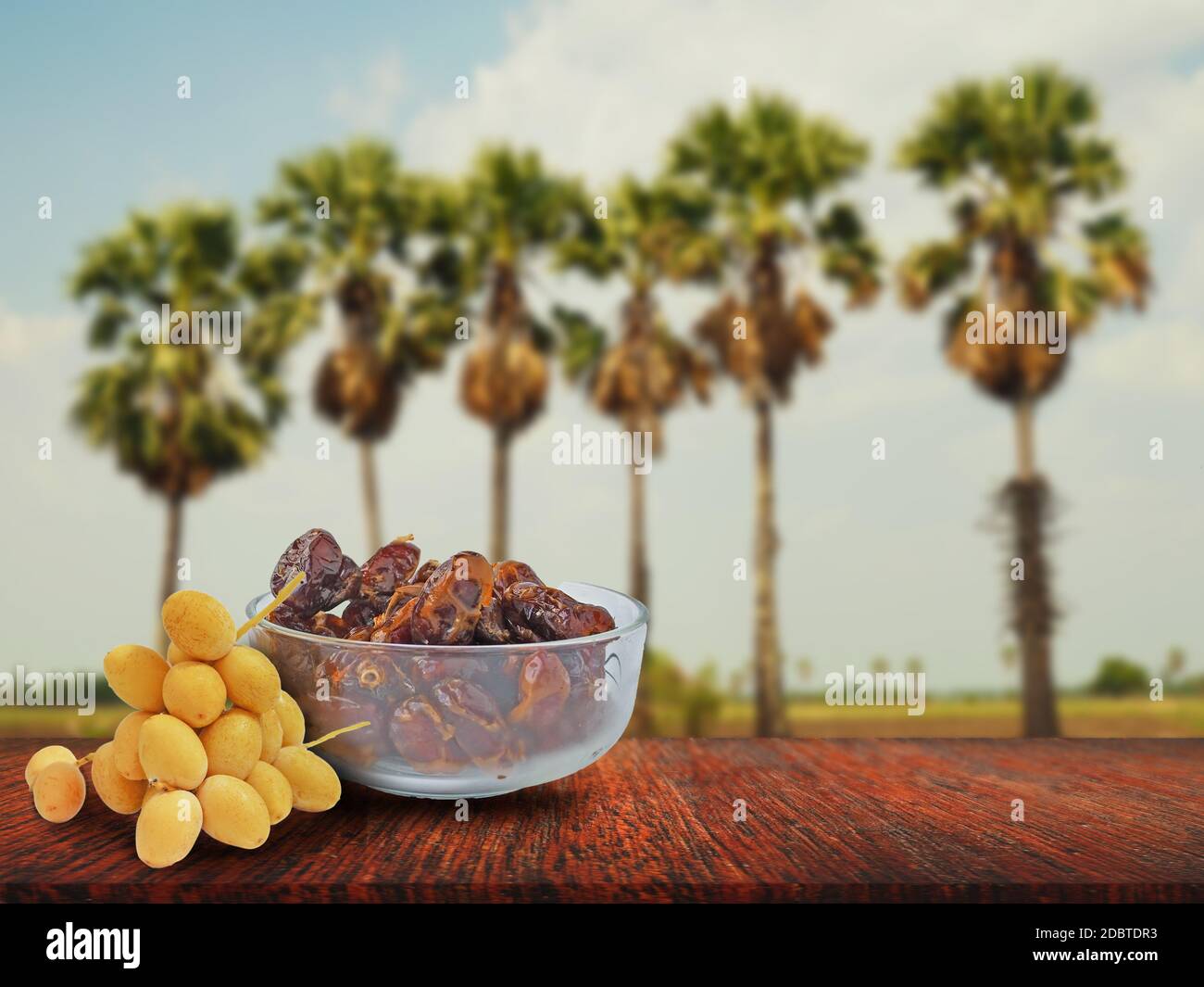 Display of fresh and dried dates on a wooden table With a blurred ...