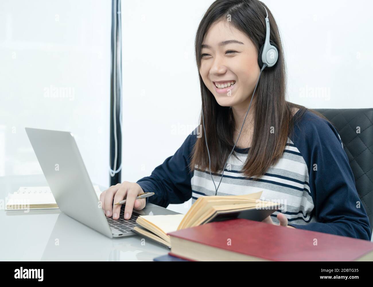 Young female student sitting in living room and learning online using ...