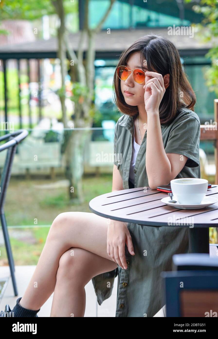Pretty woman sitting in a cafe terrace with coffee cup Stock Photo - Alamy