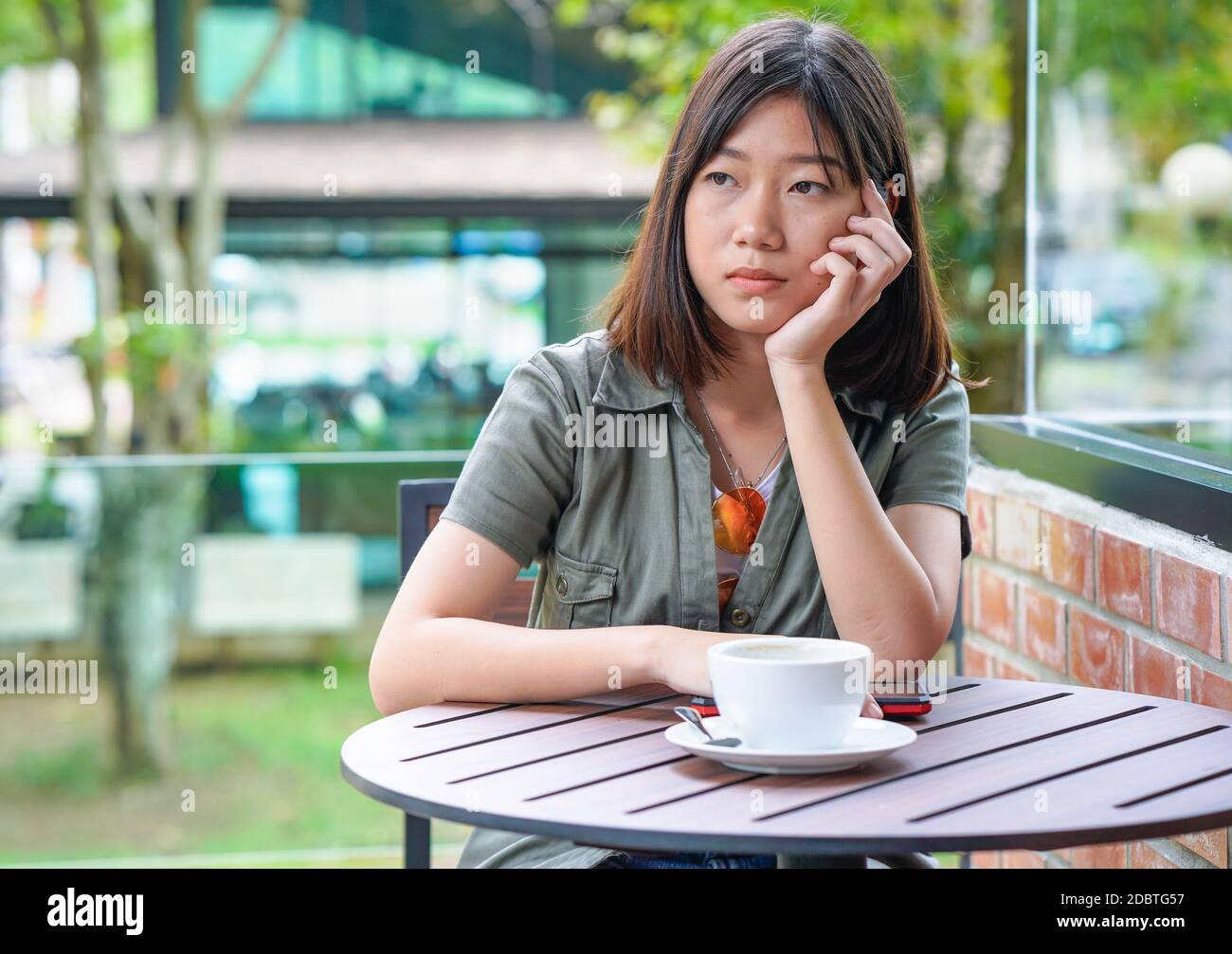 Pretty woman sitting in a cafe terrace with coffee cup Stock Photo - Alamy