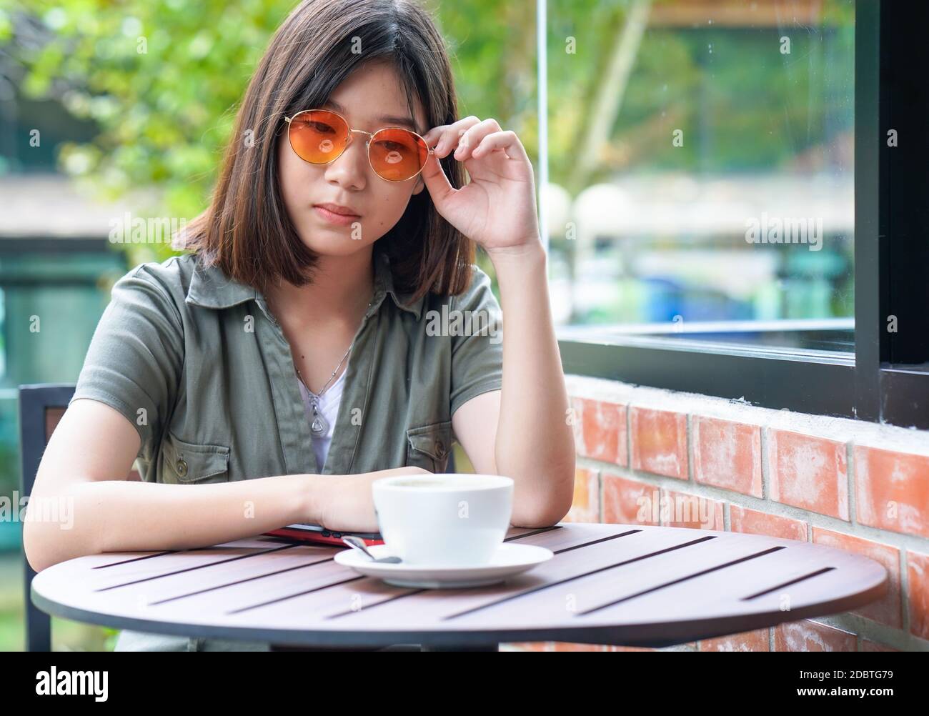 Pretty woman sitting in a cafe terrace with coffee cup Stock Photo - Alamy