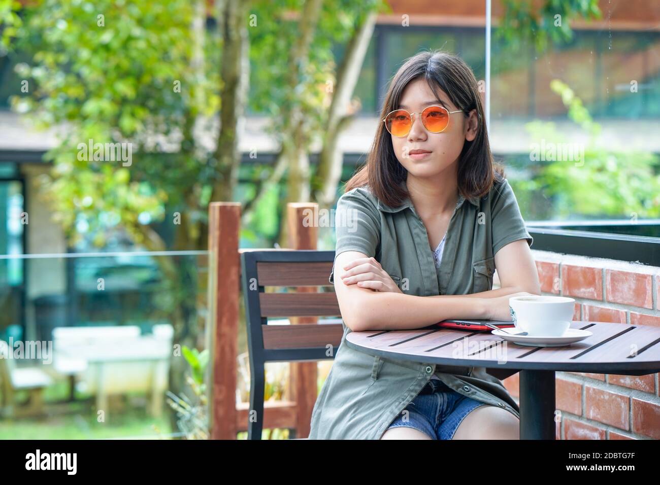 Pretty woman sitting in a cafe terrace with coffee cup Stock Photo - Alamy