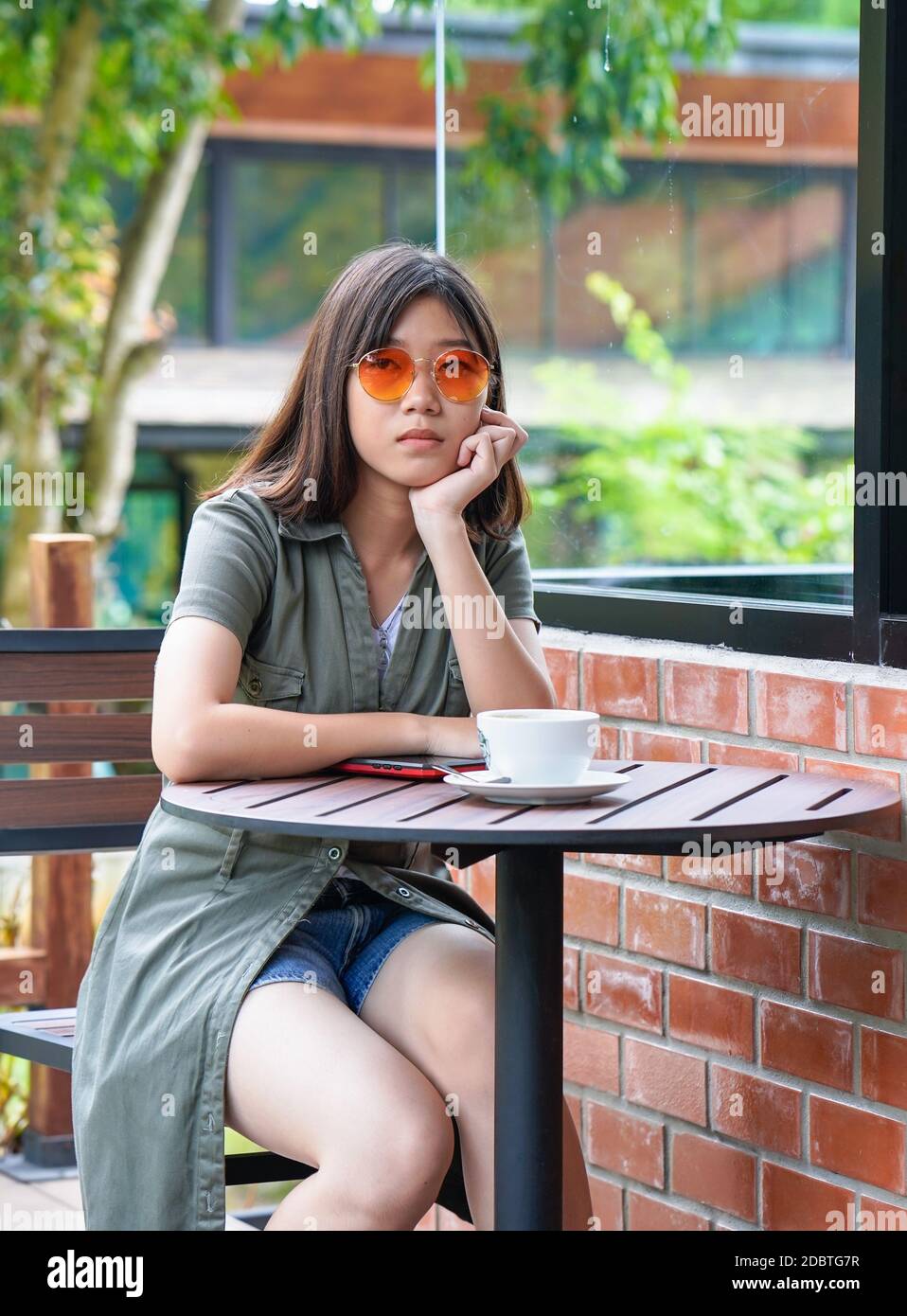 Pretty woman sitting in a cafe terrace with coffee cup Stock Photo - Alamy