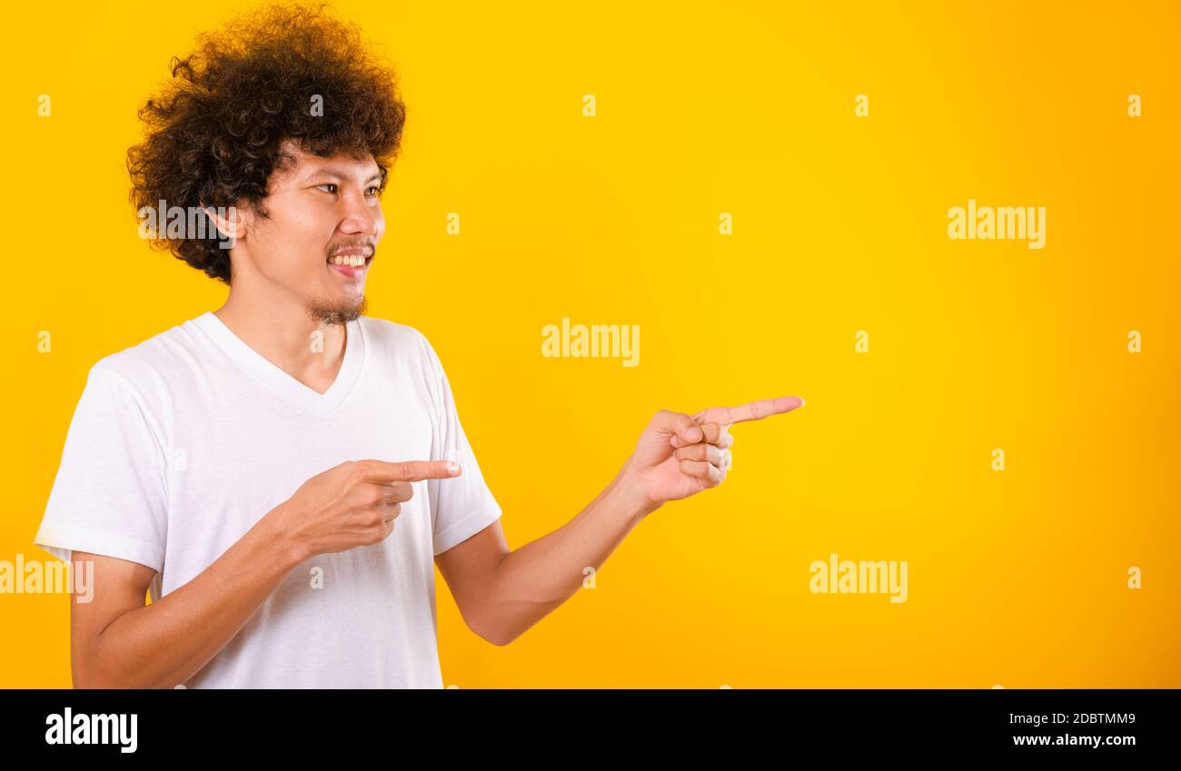 Asian Portrait happy young man curly hair White t-shirt pointing ...