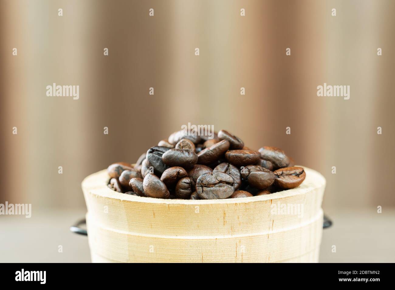 Coffee beans in a wood bucket close up Stock Photo - Alamy