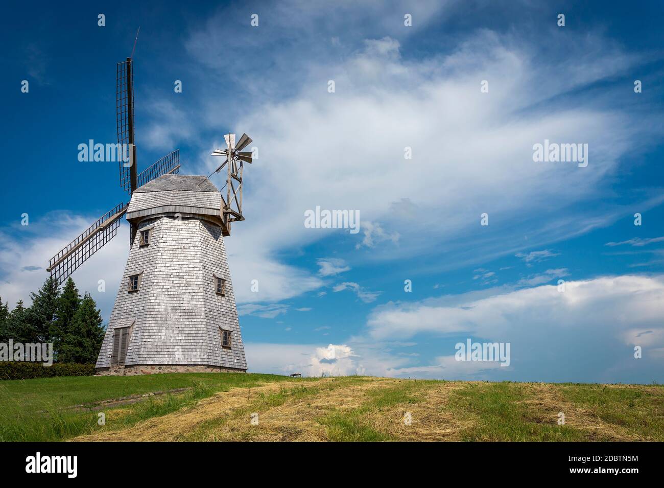 Old windmill in grassland in a country landscape under a cloudy blue ...