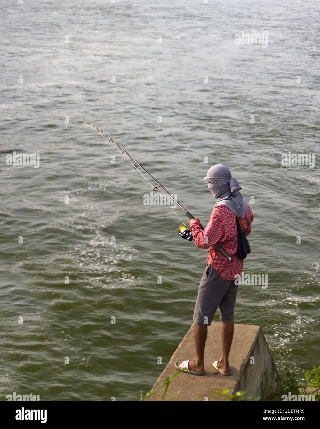 The stand fisherman and his long tackle Stock Photo - Alamy