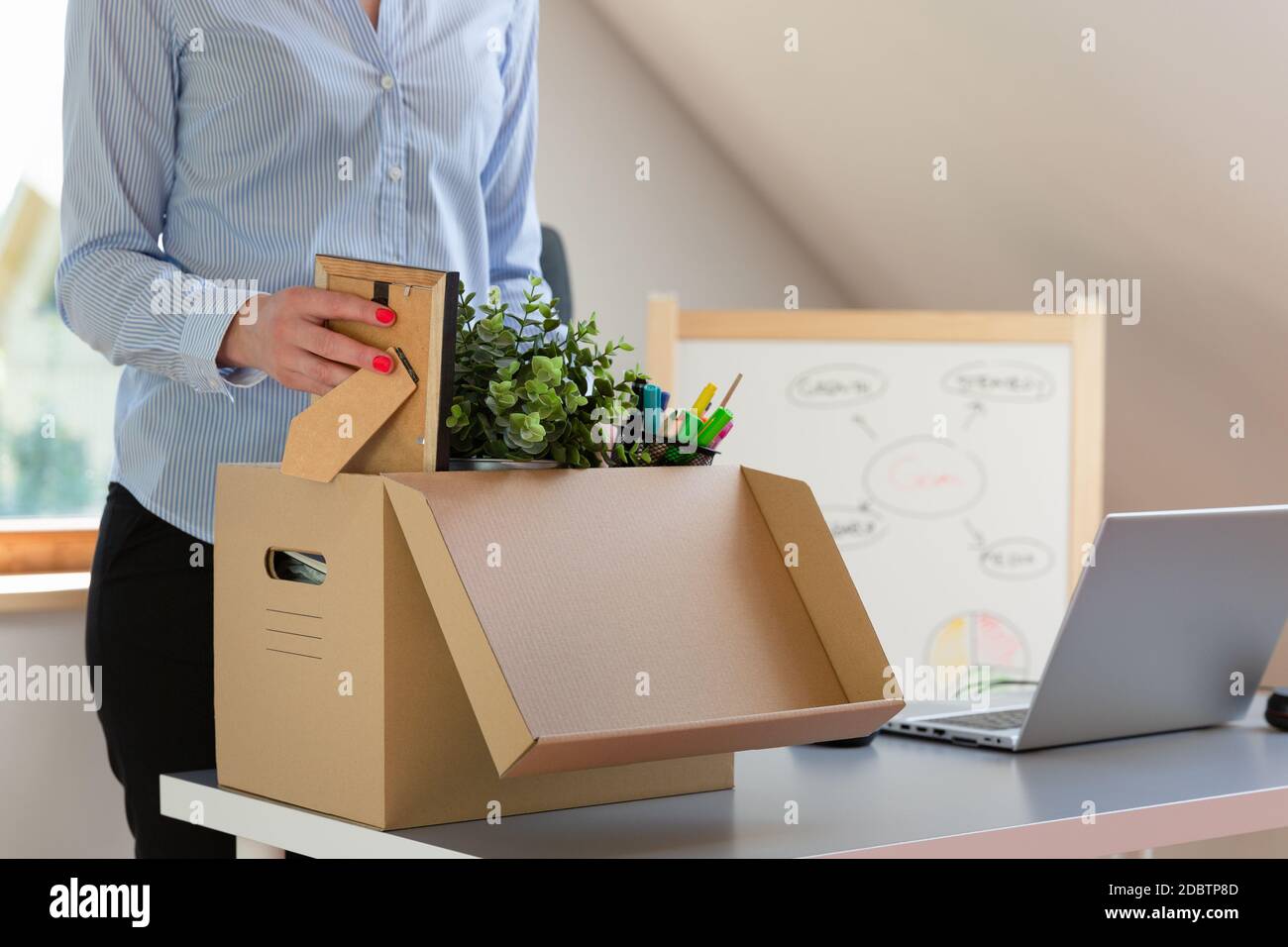 Beautiful business woman carrying a box of office stuff. New work ...