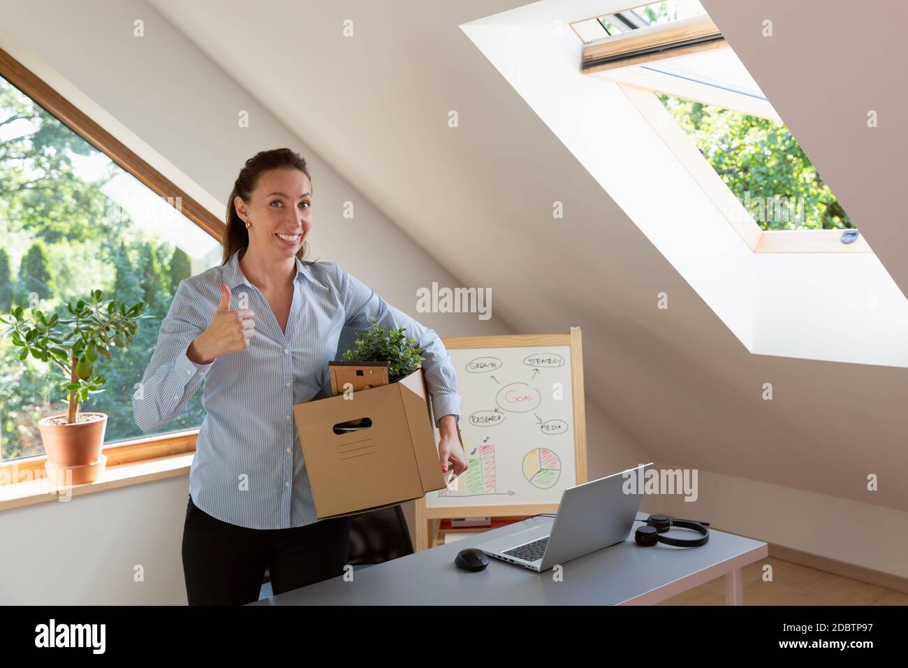 Beautiful business woman carrying a box of office stuff. New work ...