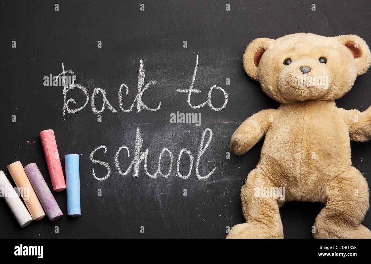 lettering back to school in white chalk on a black school board and a ...
