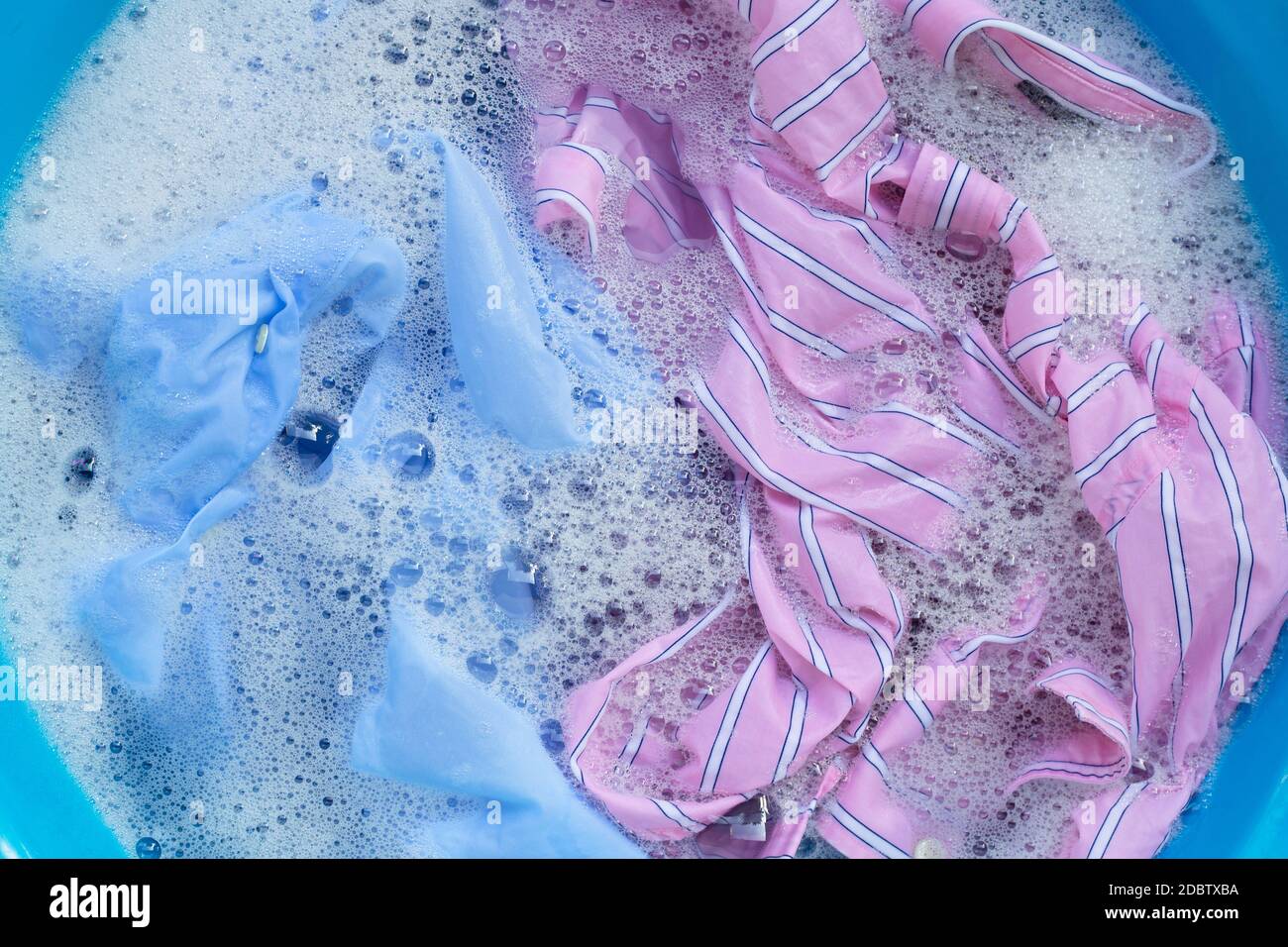 Top view of color clothes soak in powder detergent water dissolution ...