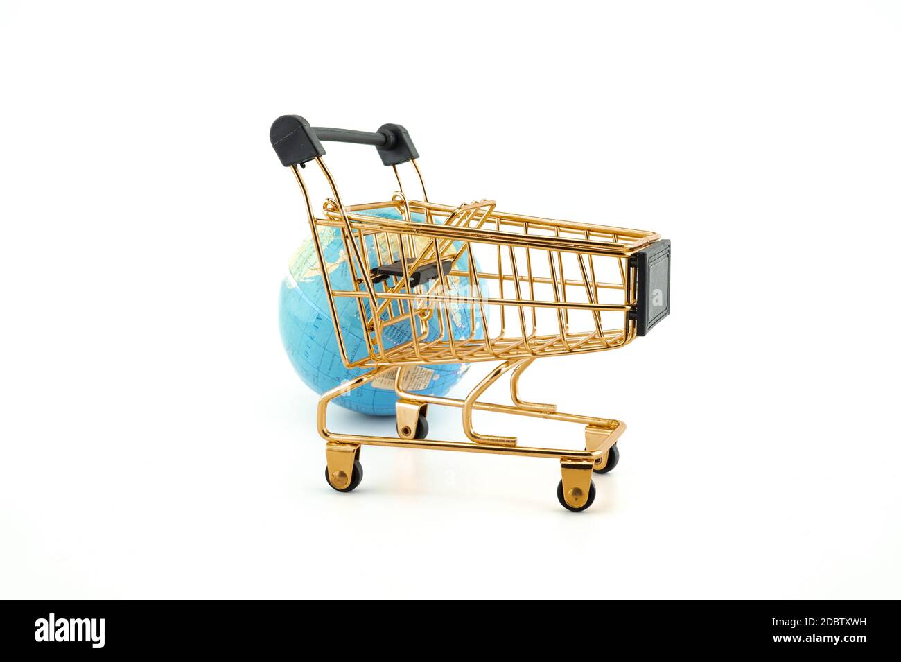 Golden shopping cart in front of a world globe isolated on white ...