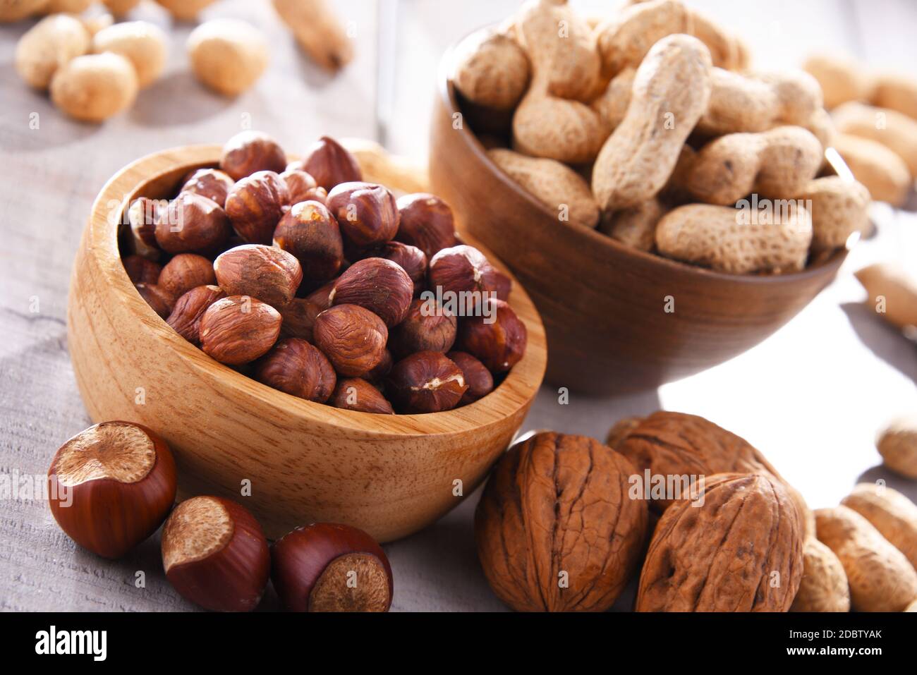 Composition with two bowls of hazelnuts and peanuts Stock Photo - Alamy