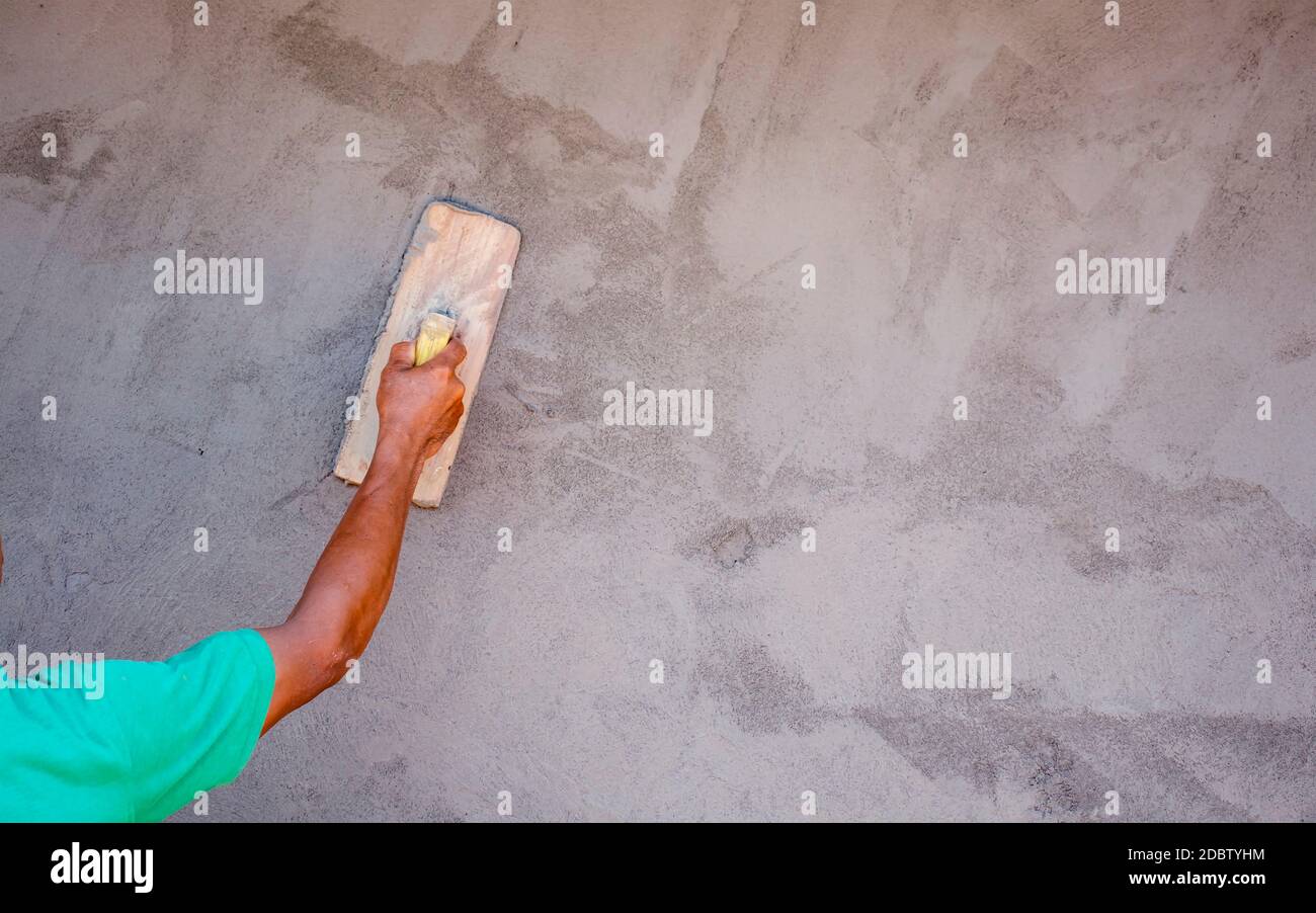 Close-up of workers using plaster trowel to plaster the walls for house ...