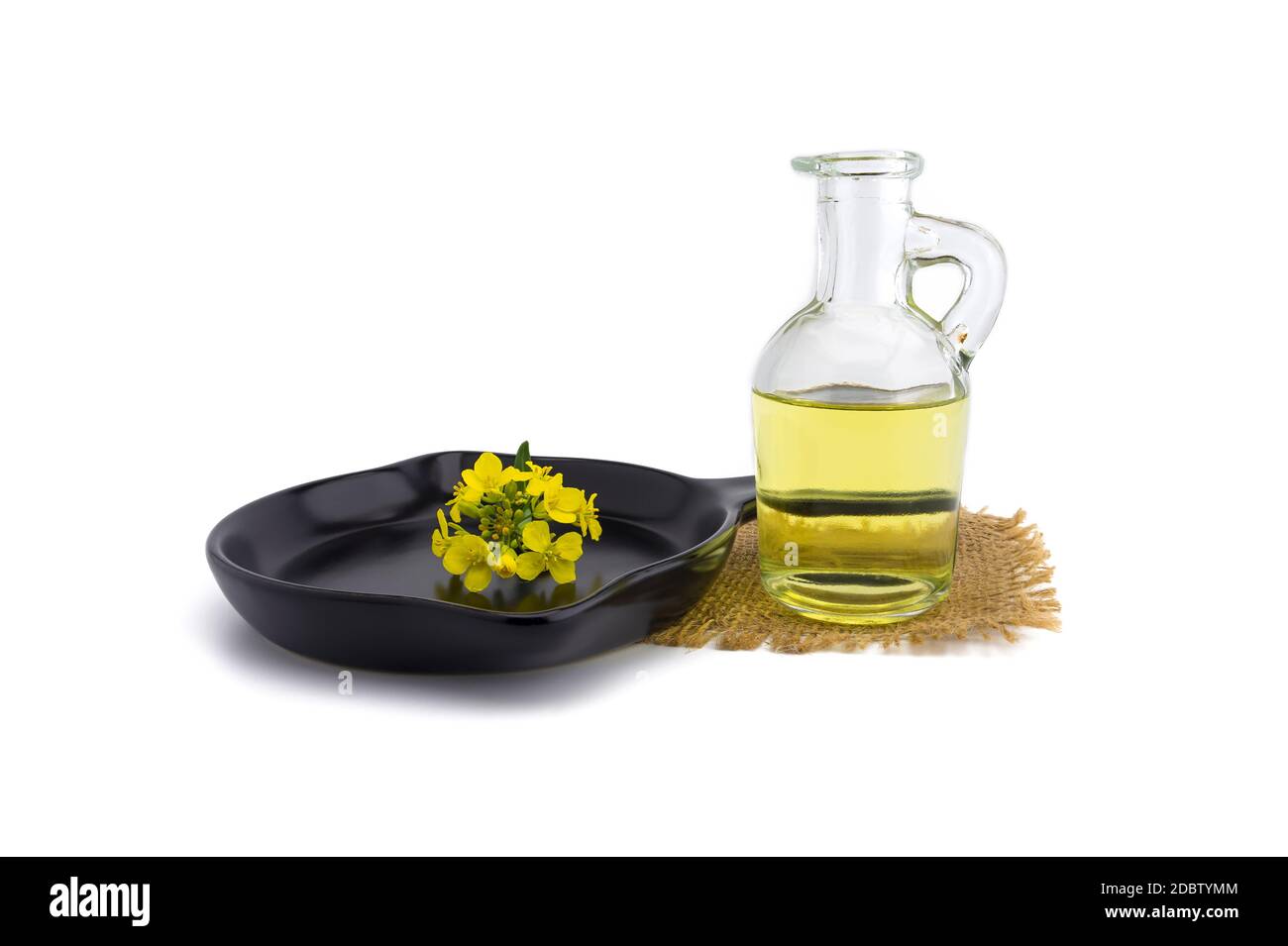 Small sprig of vivid yellow mustard or rapeseed flowers with decanter ...