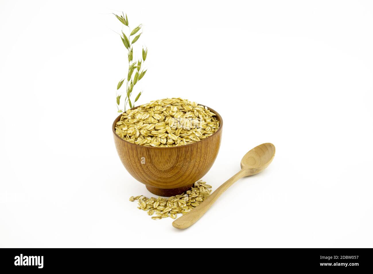 Oat flakes in the bowl, wooden spoon and oat branch isolated on white ...