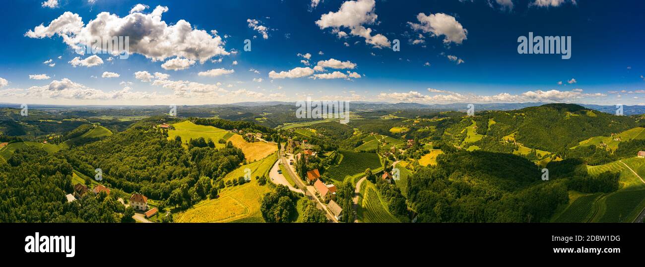 Aerial panorama of of green hills and vineyards with mountains in ...