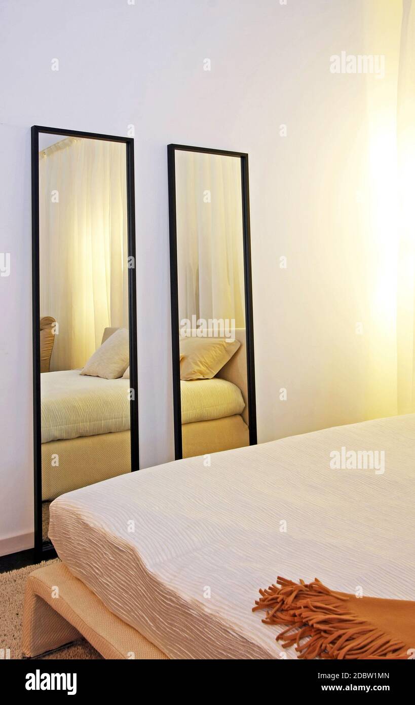 Interior shot of bedroom with mirrors reflections Stock Photo - Alamy