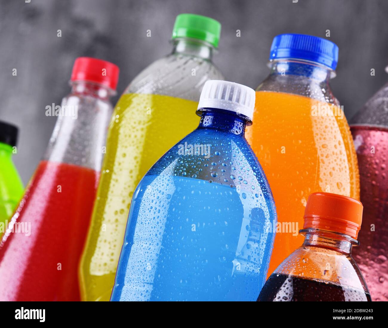 Plastic bottles of assorted carbonated soft drinks in variety of colors ...
