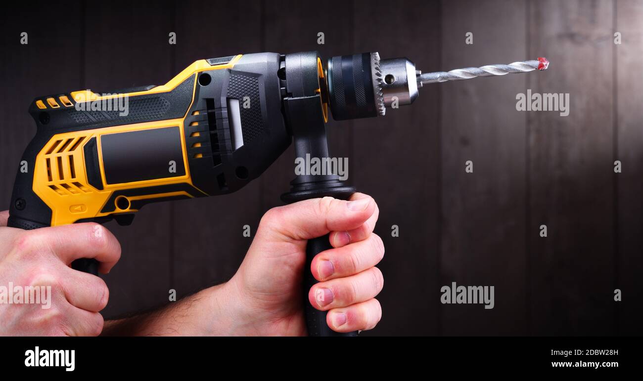 Male hands holding power drill Stock Photo - Alamy