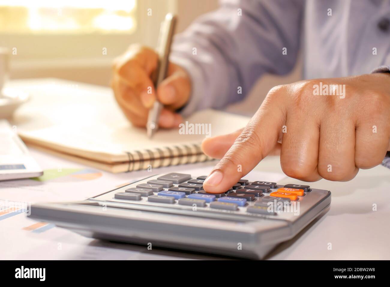 Close-up of women using calculators and note-taking, accounting reports ...