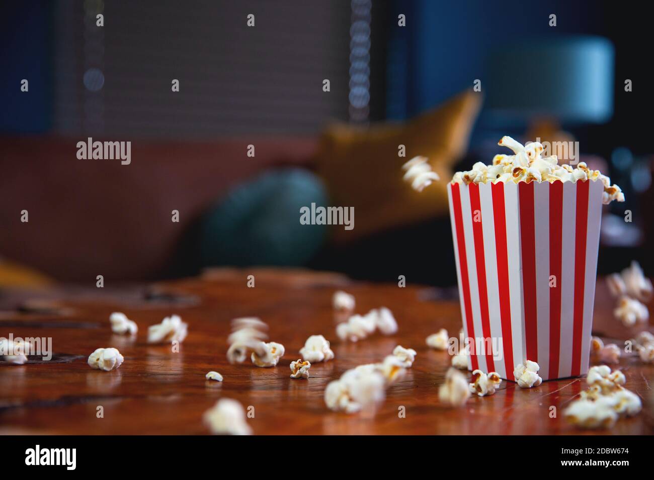 Popcorn flying out of cardboard box. red and white striped popcorn ...