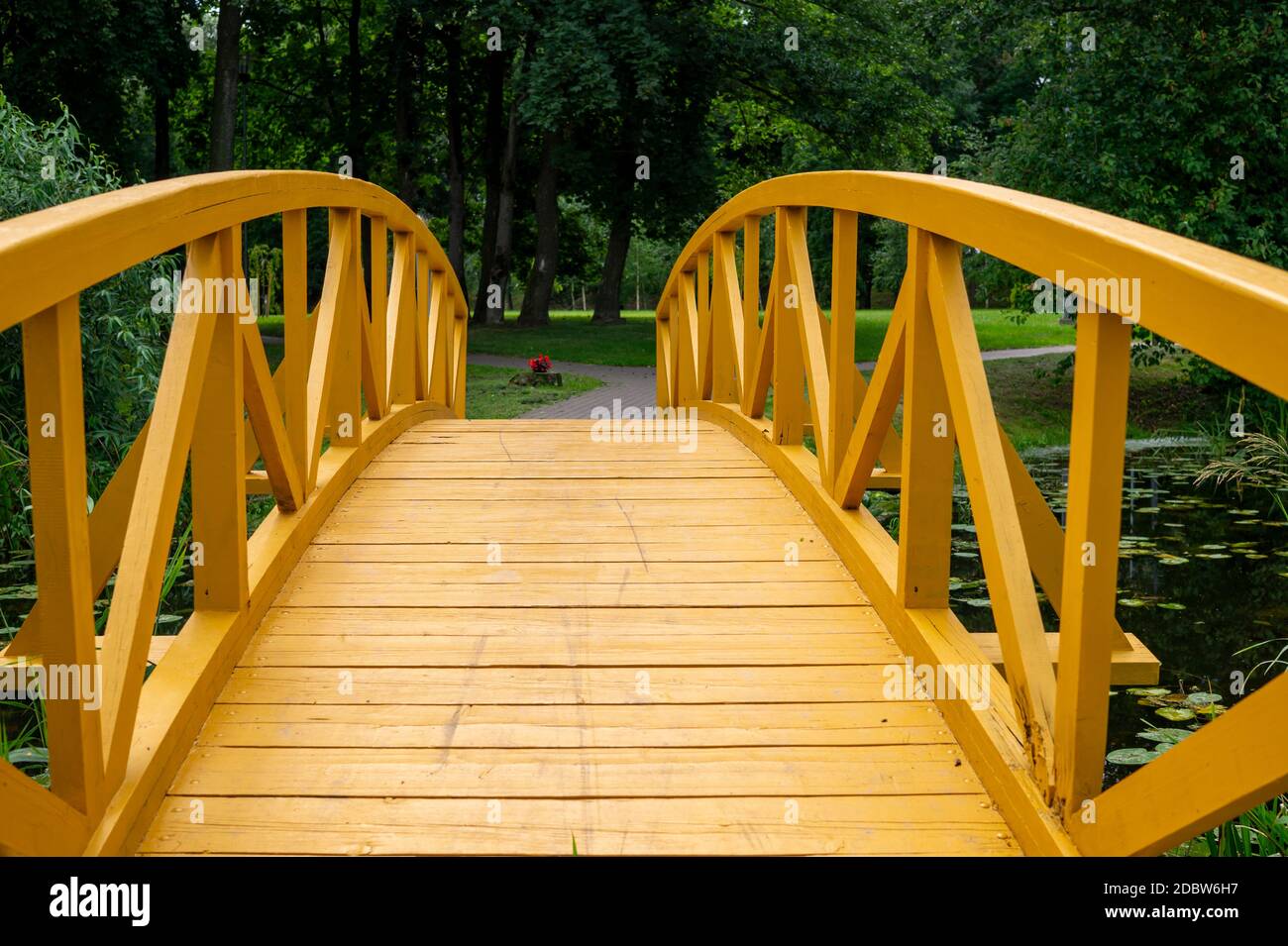 Empty arched wooden pedestrian bridge curving away in a receding ...