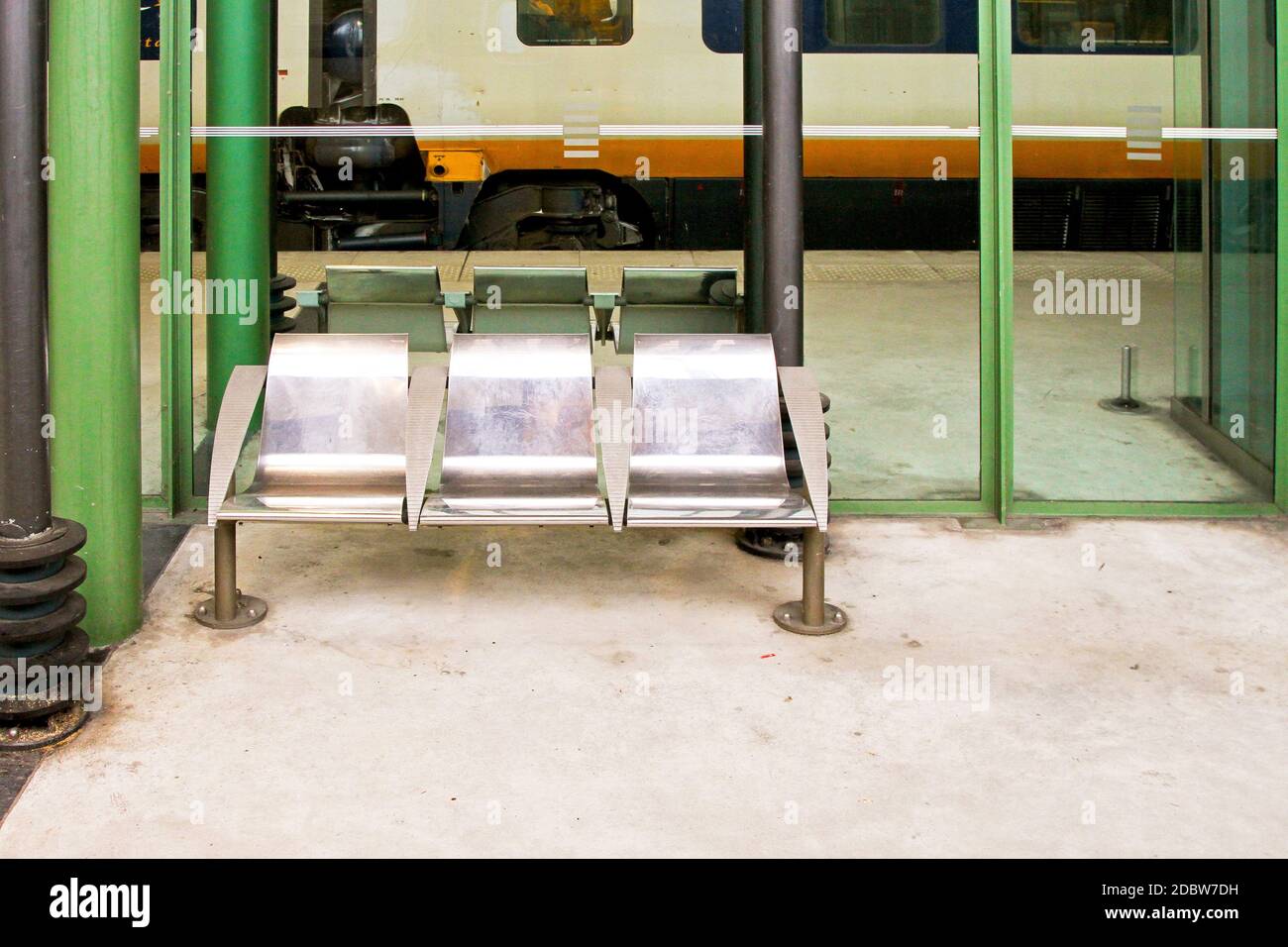Metal bench seat at fast train platform Stock Photo - Alamy