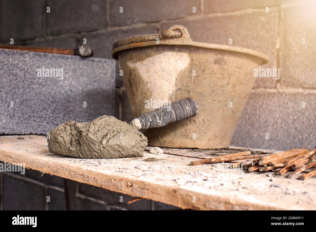 Cement or mortar and trowel with wet cement laid on wood, paper for ...
