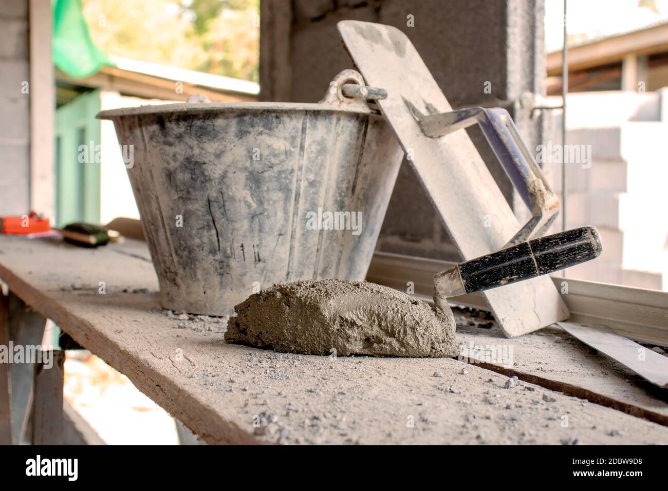 Cement or mortar and trowel with wet cement laid on wood, paper for ...