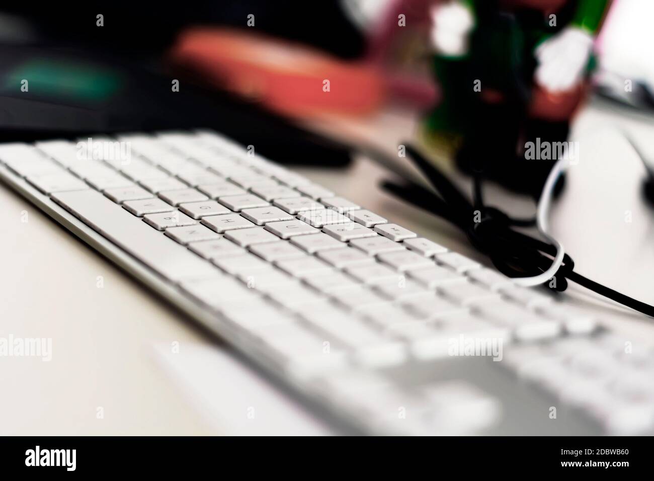 a modern gray computer keyboard with white keys on an office table ...