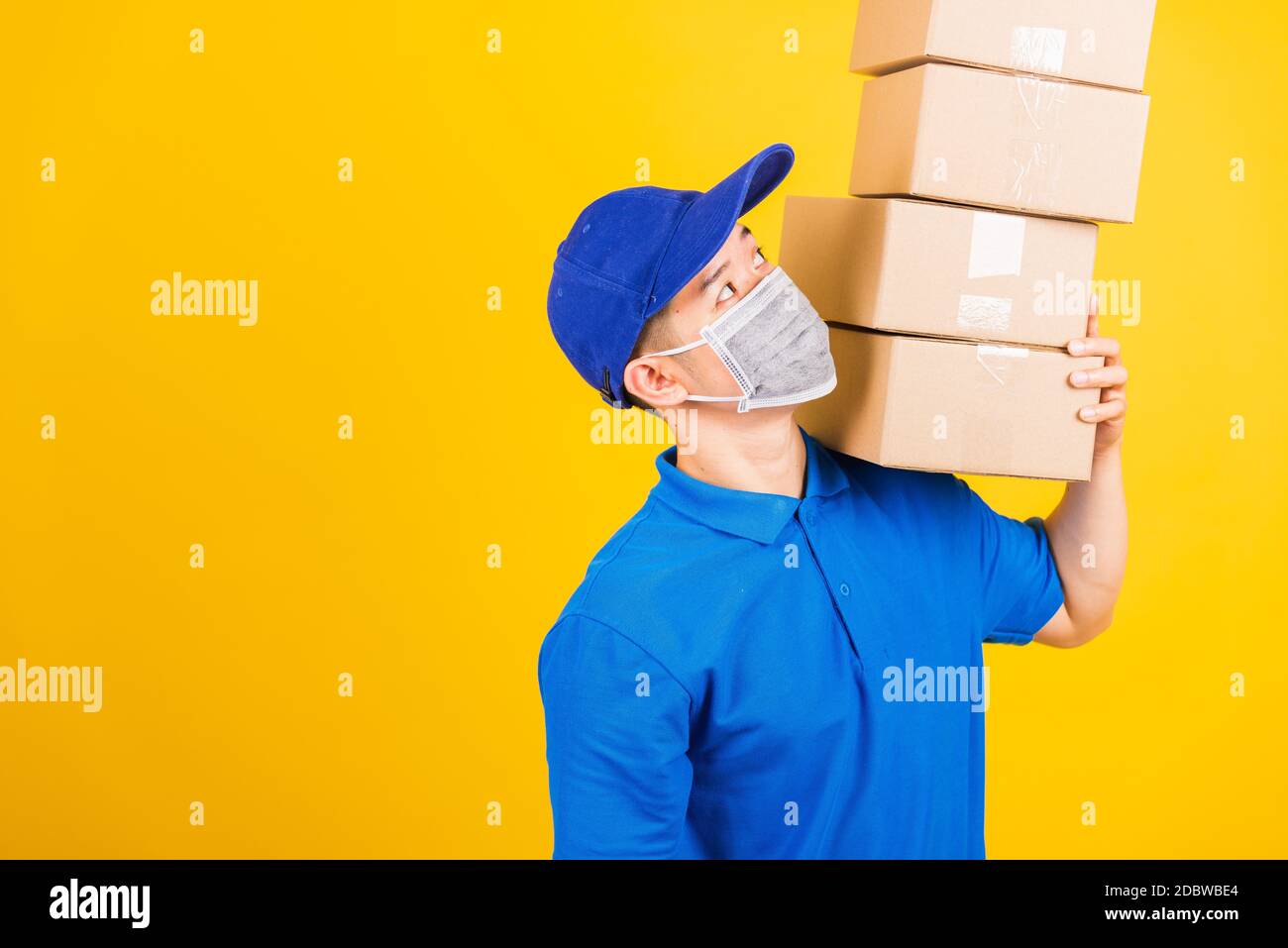 Asian young delivery worker man in blue t-shirt and cap uniform wearing ...