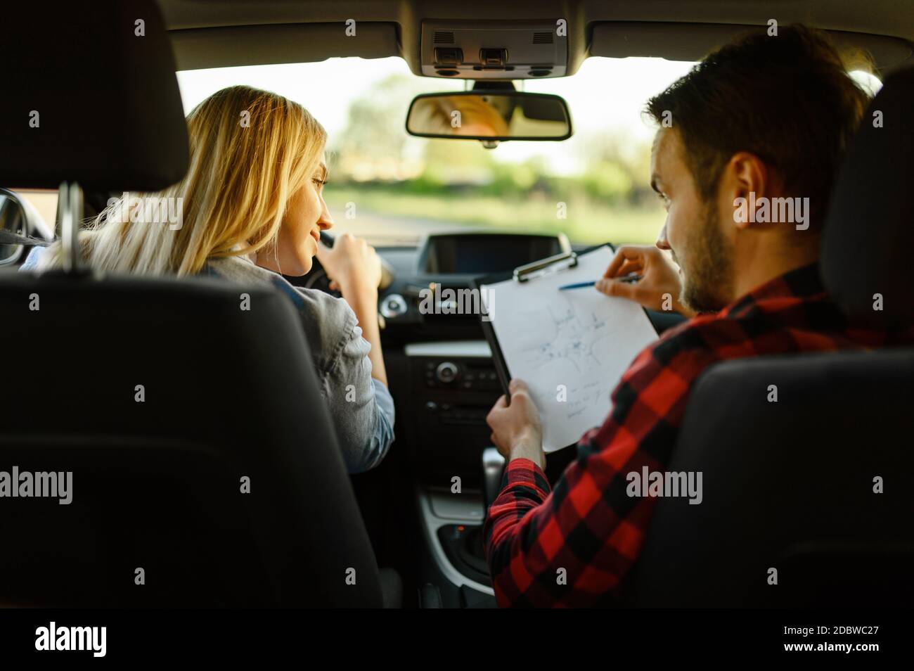 Instructor helps the woman to drive the car, driving school. Man ...