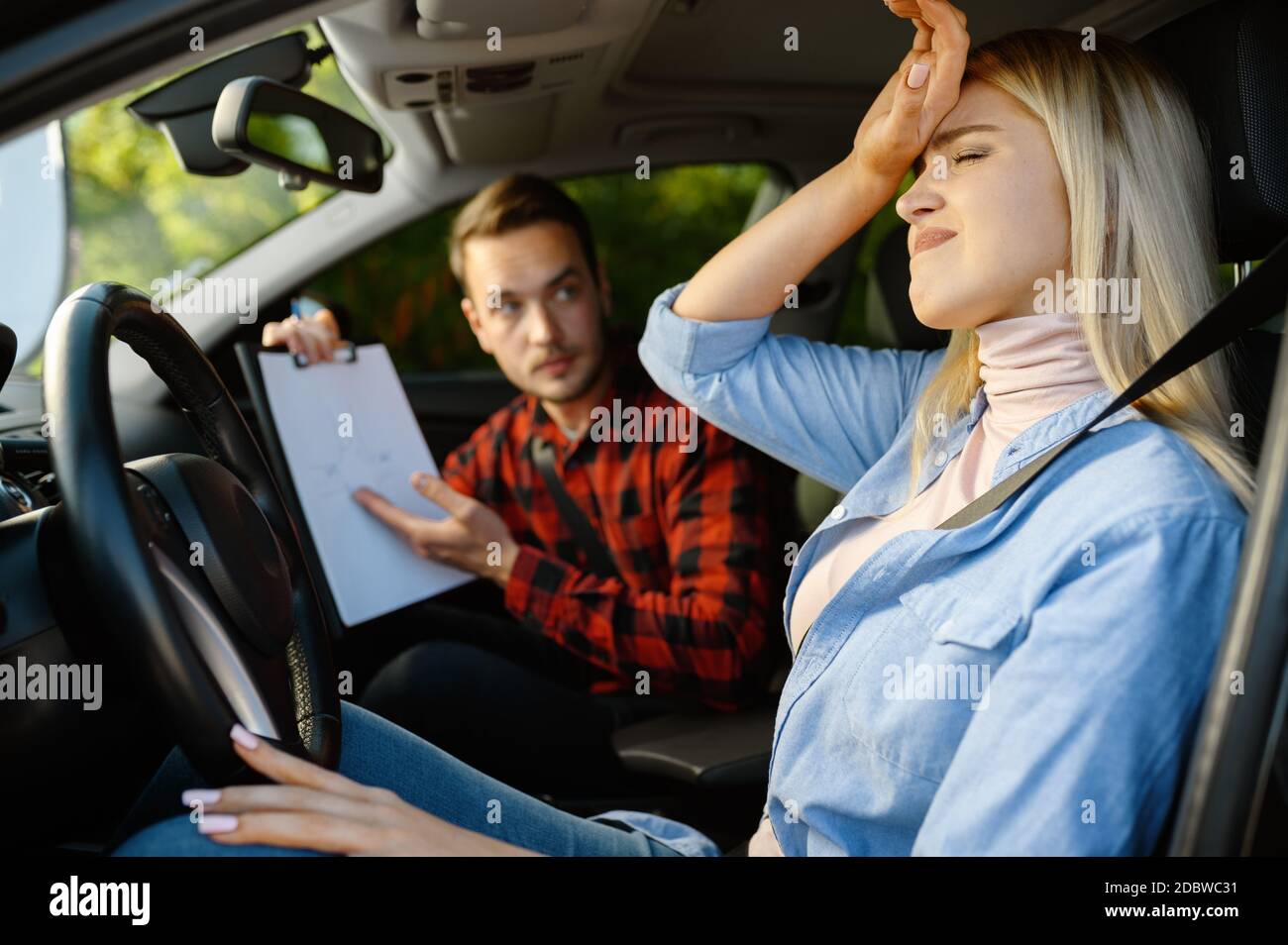 Woman and instructor with checklist in car, driving school. Man ...