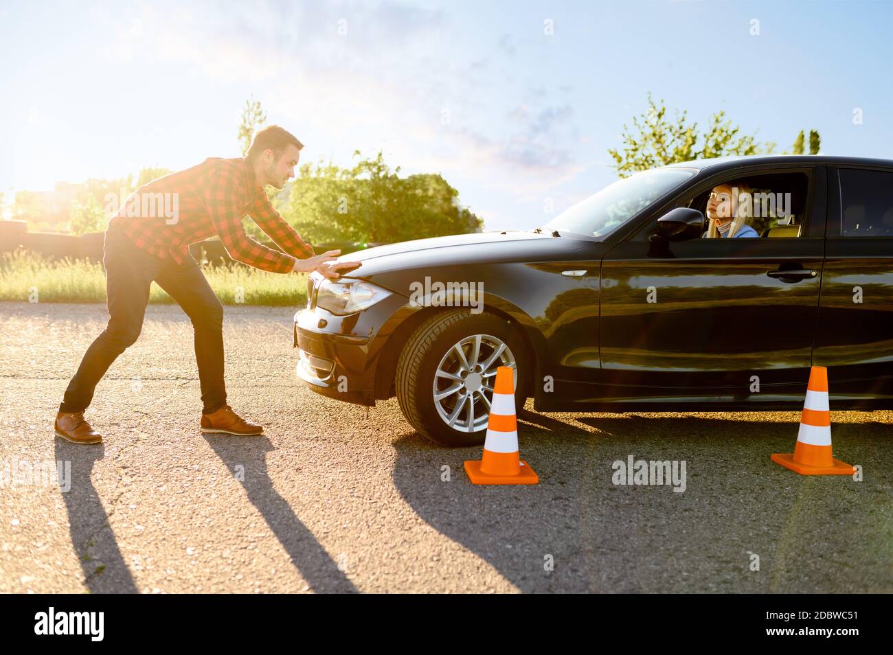 Female student passes between cones, lesson in driving school. Man ...