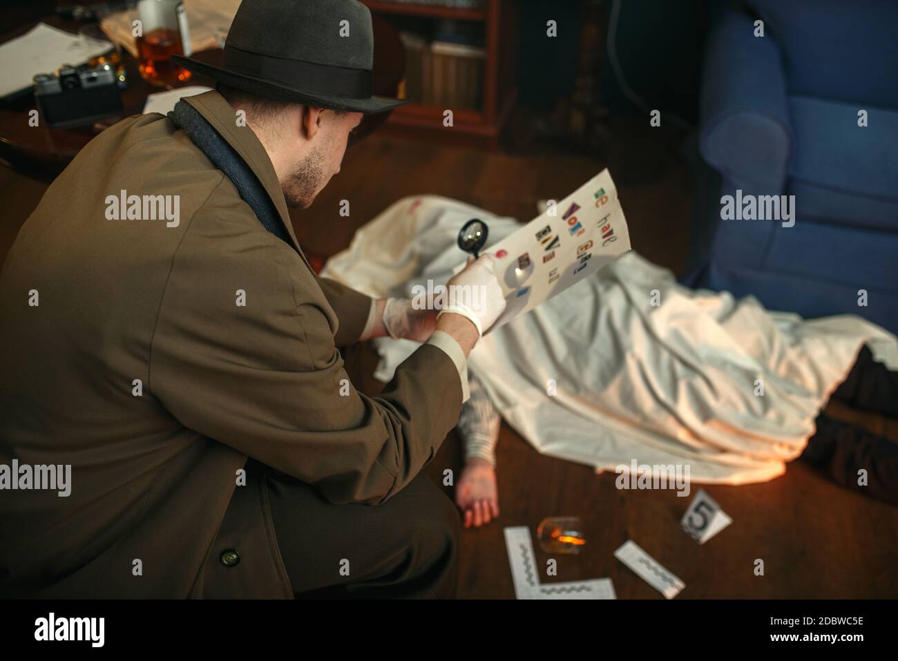 Male detective with magnifying glass looking killer's letter, evidence ...