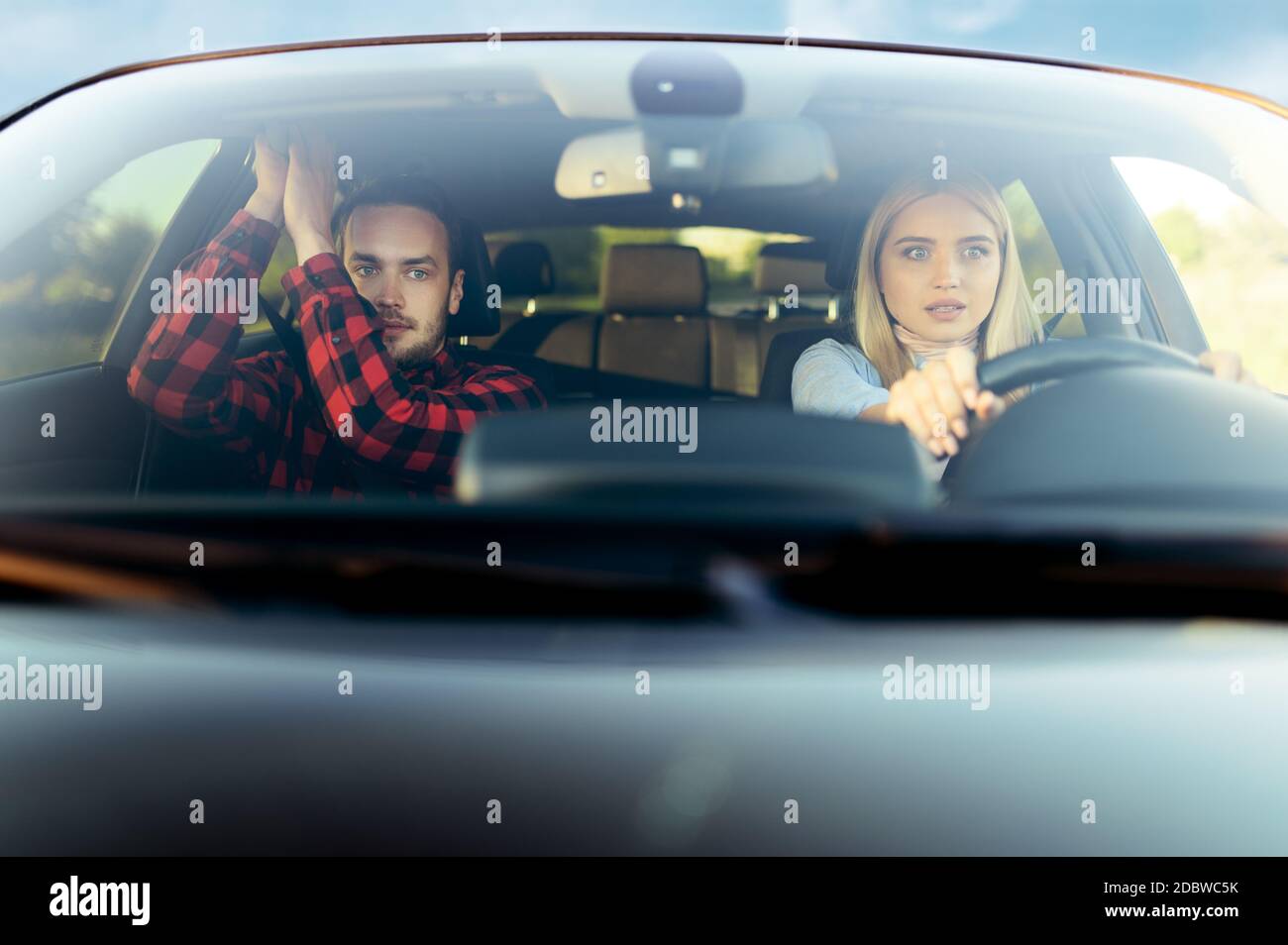 Scared woman and instructor in car, front view, driving school. Man ...