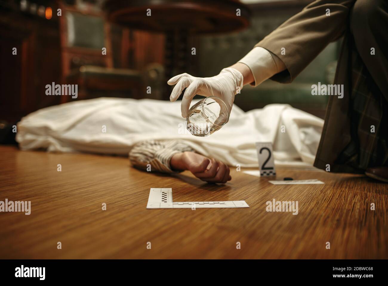 Male detective with magnifying glass looking evidence at the crime ...