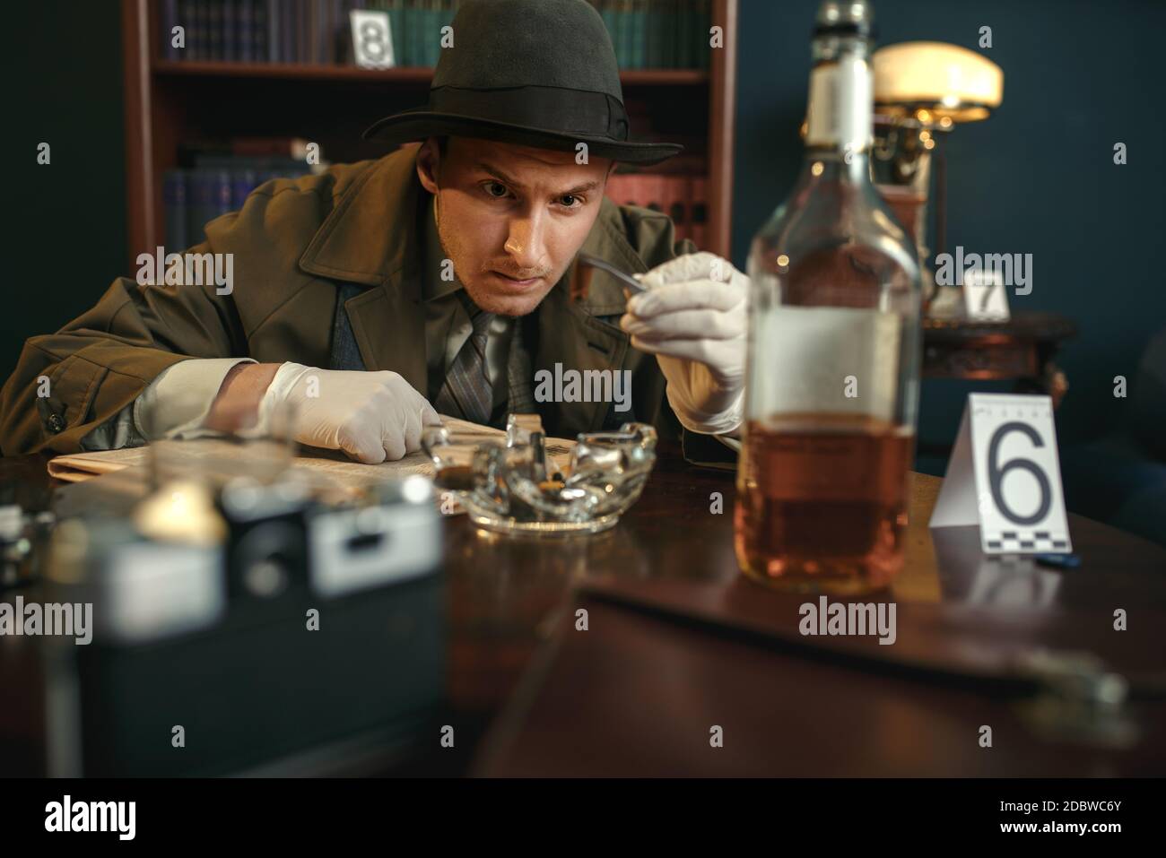 Male detective with tweezers finds evidence at the crime scene, retro ...