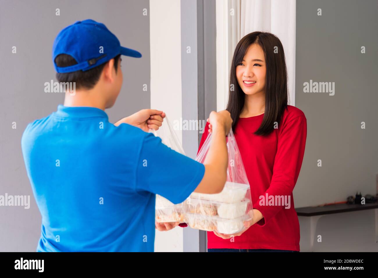 Asian young delivery man in blue uniform he making grocery service ...