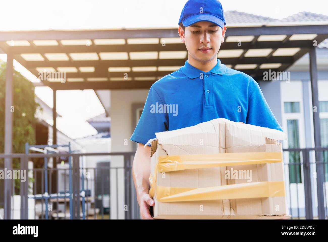 Asian young delivery man in blue uniform he emotional falling courier ...