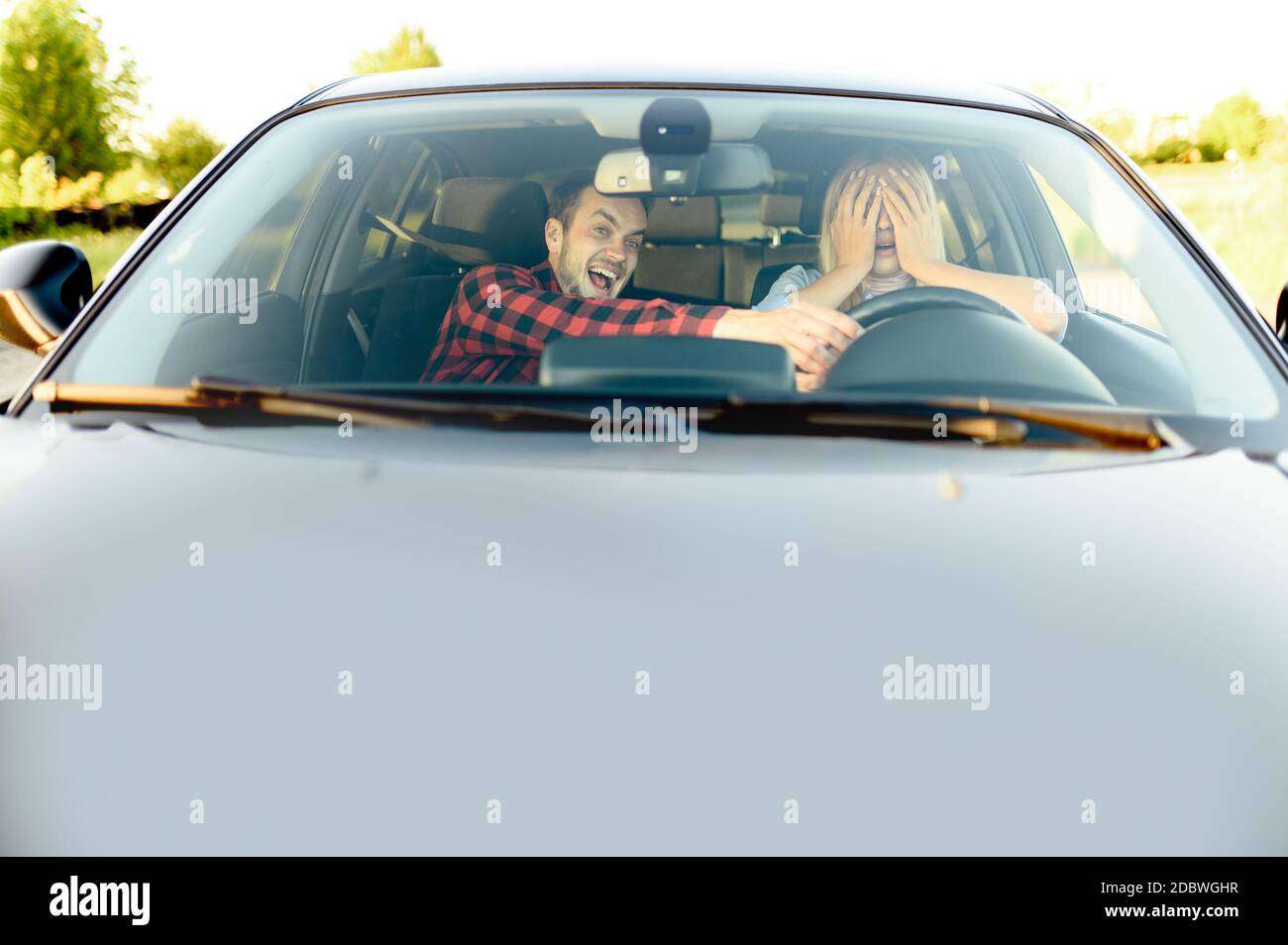 Scared woman and instructor in car, front view, driving school. Man ...