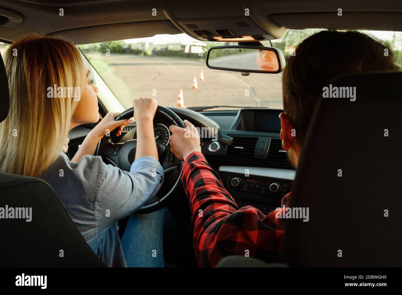 Instructor helps the woman to drive the car, driving school. Man ...