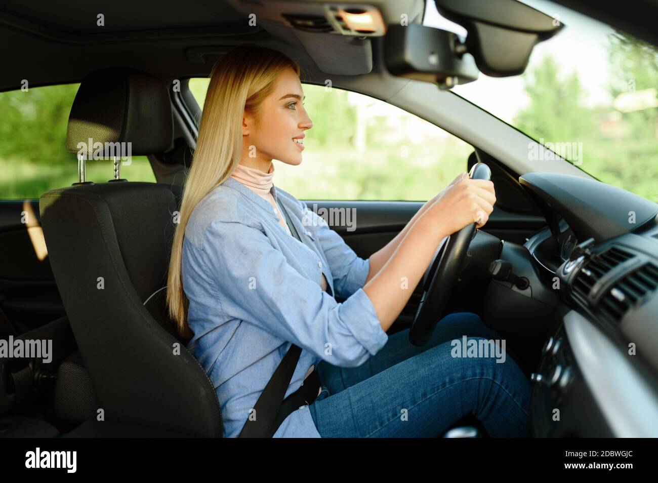 Cheerful female student in the car, lesson in driving school. Man ...