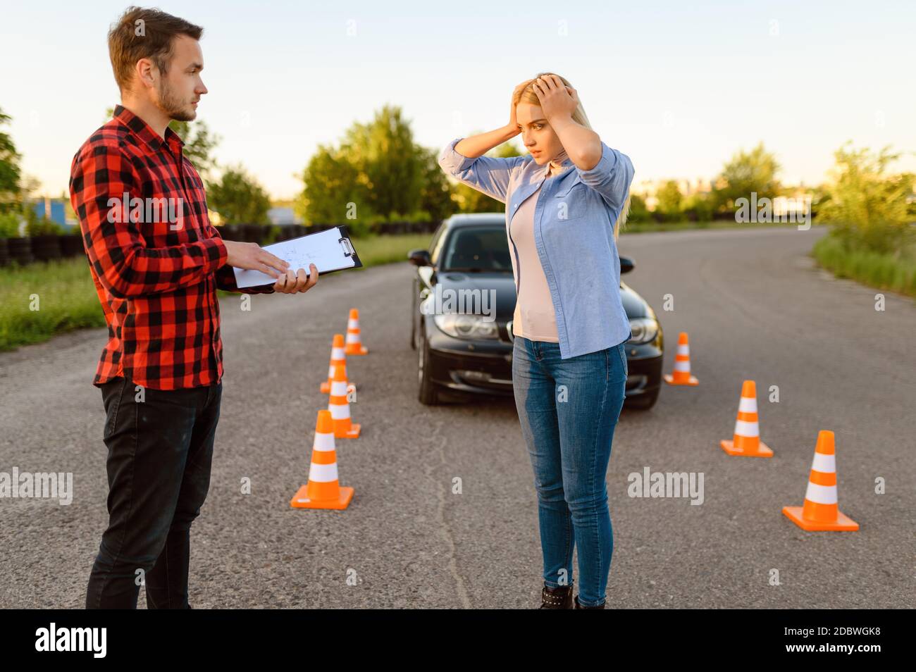 Stressed female student and instructor with checklist on road, lesson ...