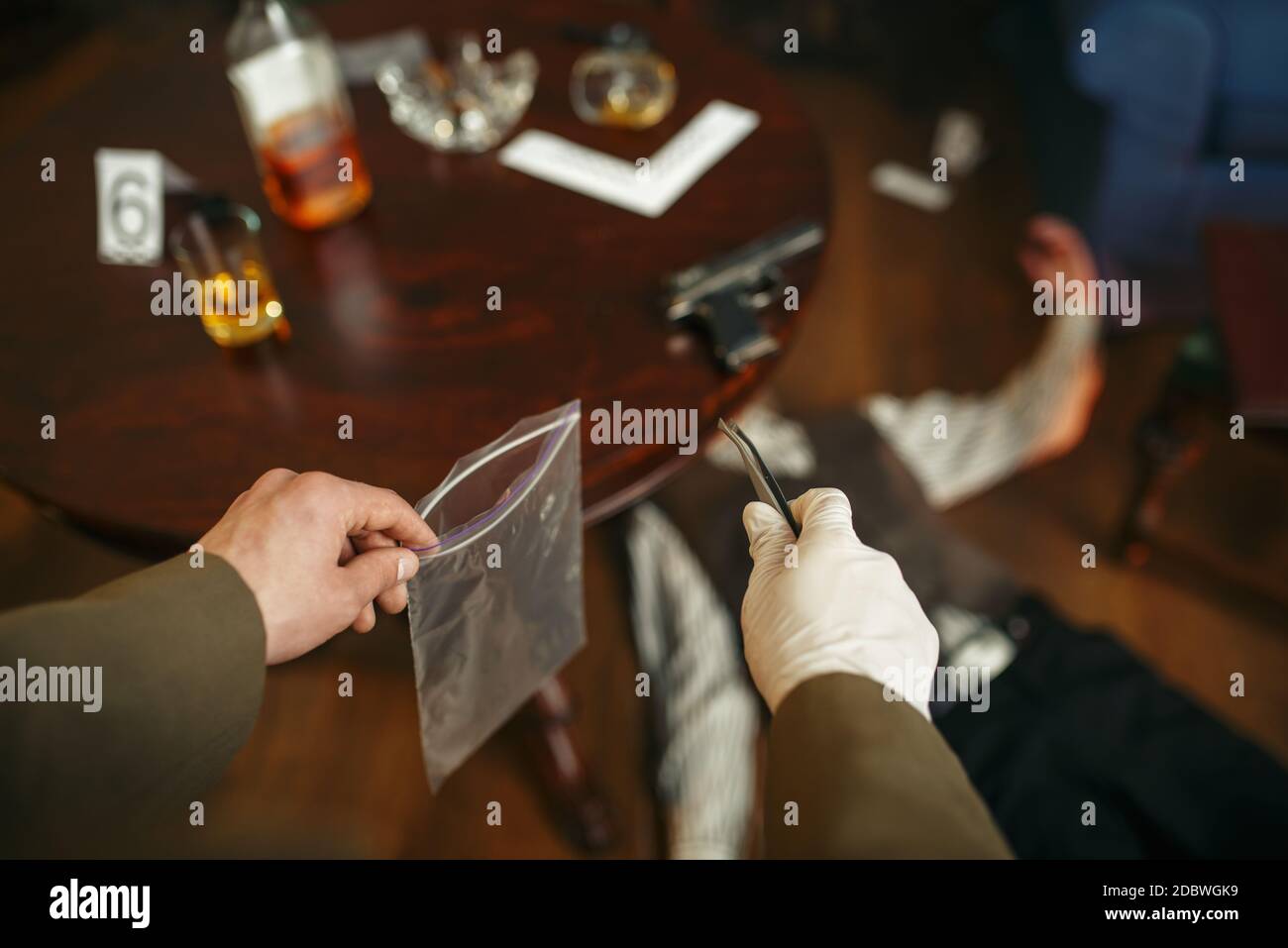 Male detective with tweezers searches evidence at the crime scene ...