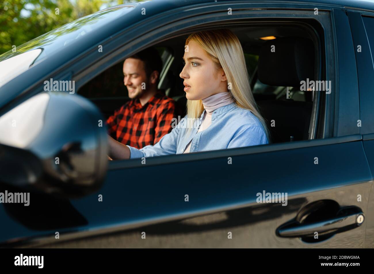 Female student and male instructor in car, driving school. Man teaching ...