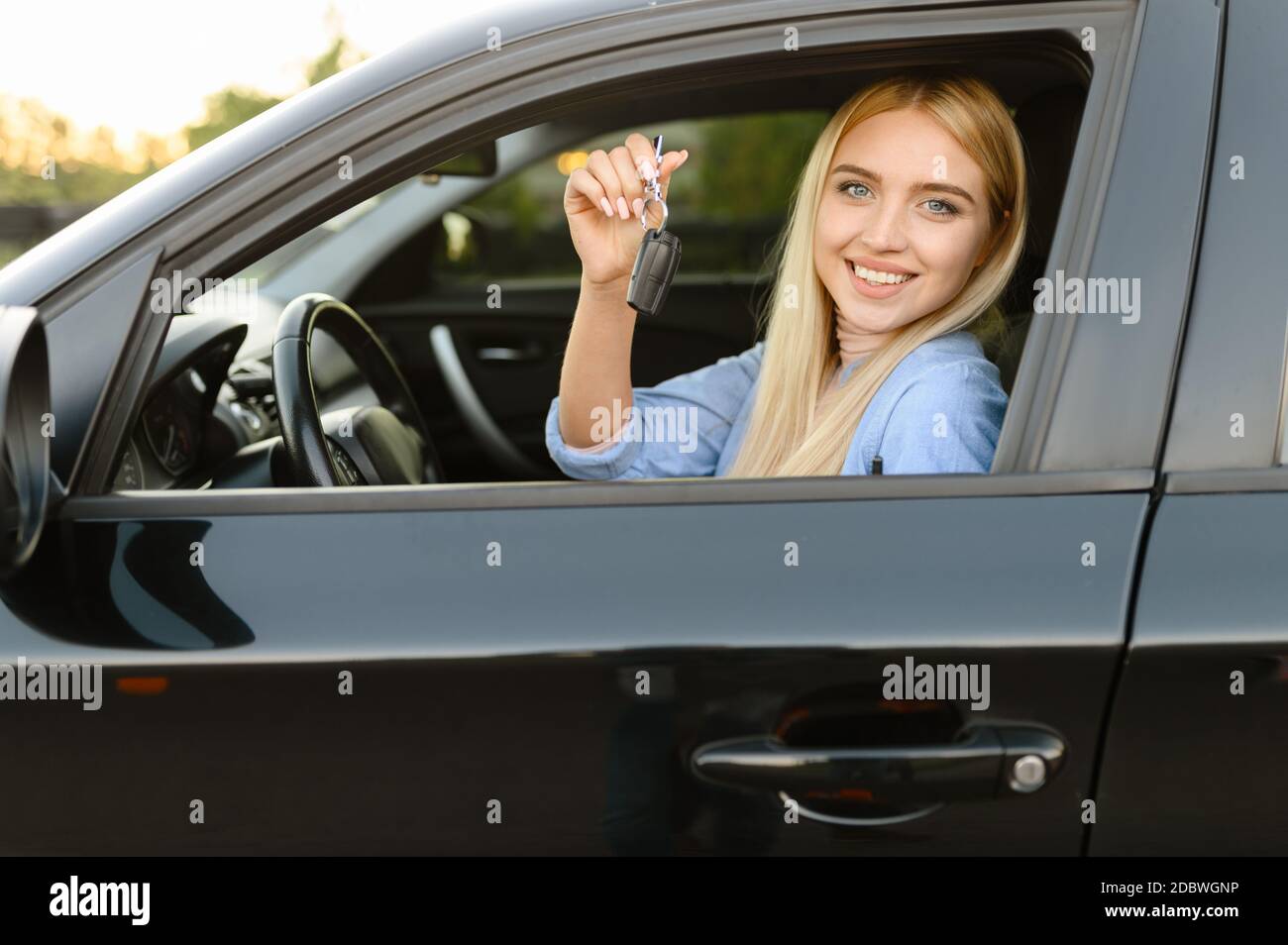 Happy woman with keys poses in car, lesson in driving school. Lady ...